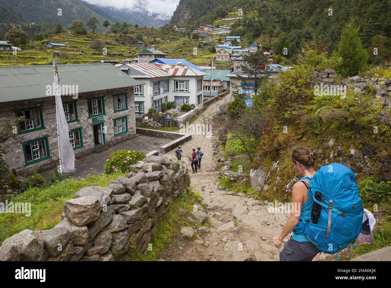 A group backpacking through a town in a valley of the Himalayas; Nepal ...