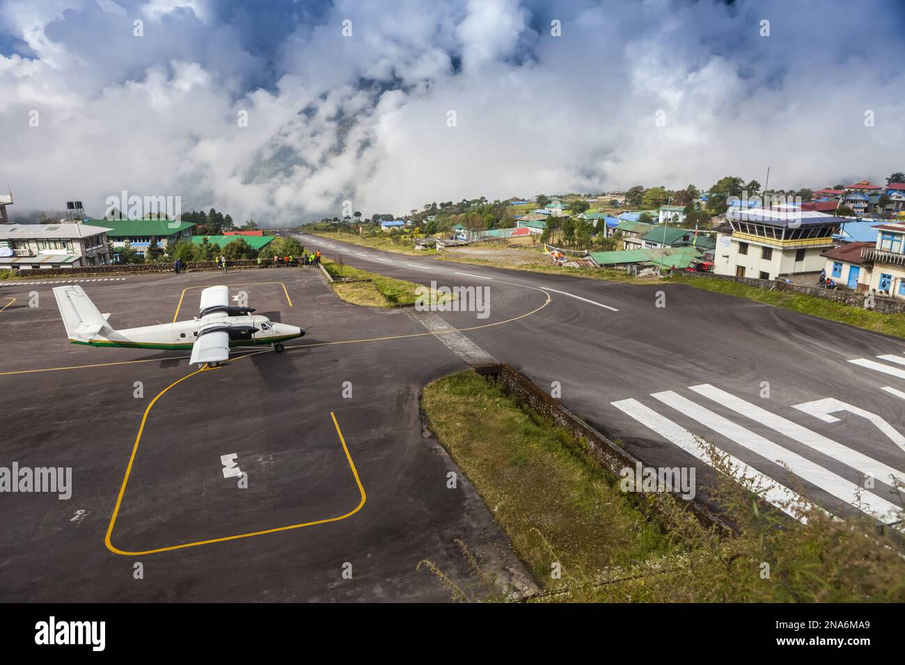 A Tara Airlines plane taxiing to the runway, with airport workers in ...