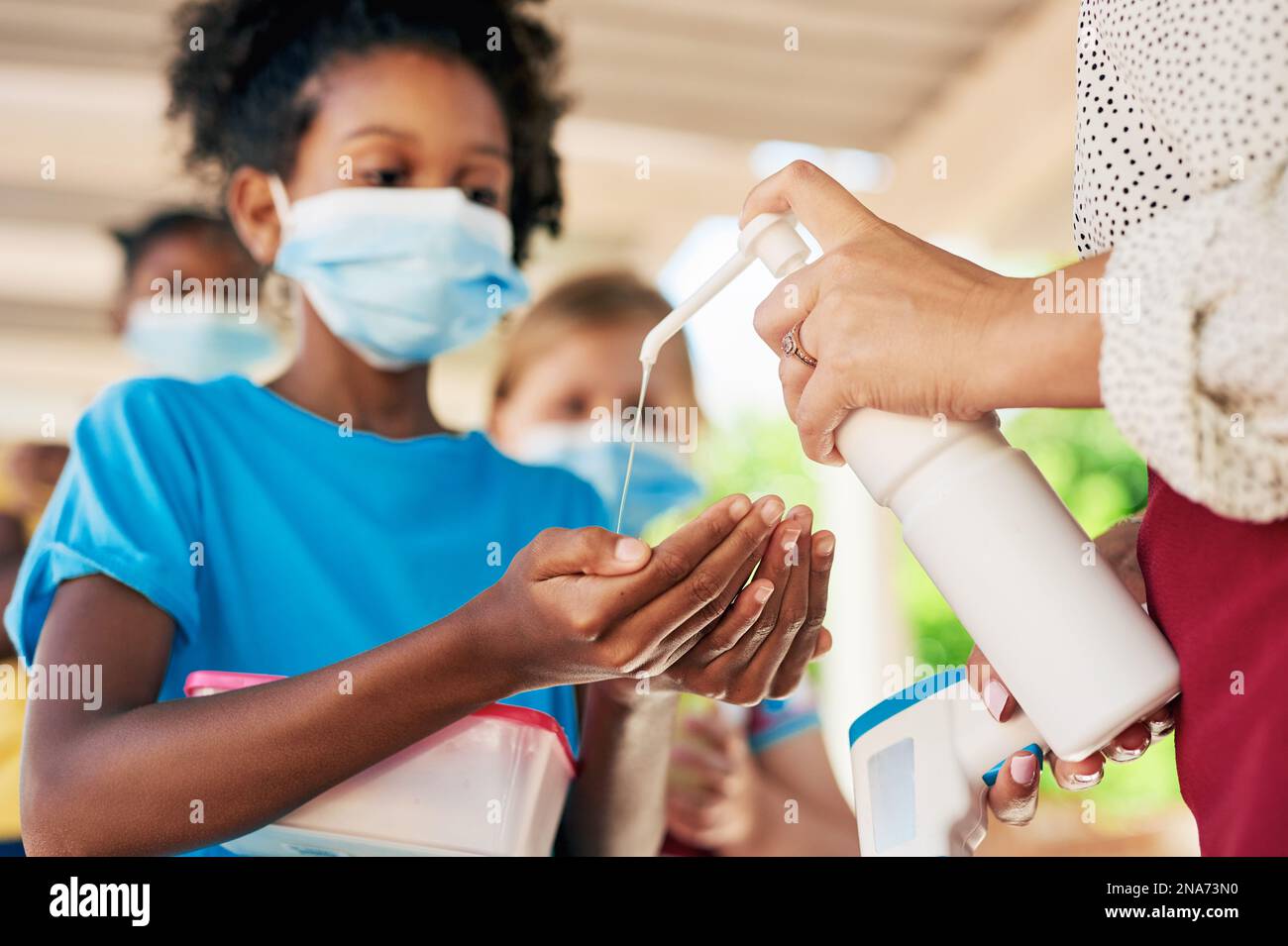 Dont forget to sanitise. a young girl wearing a face mask and ...