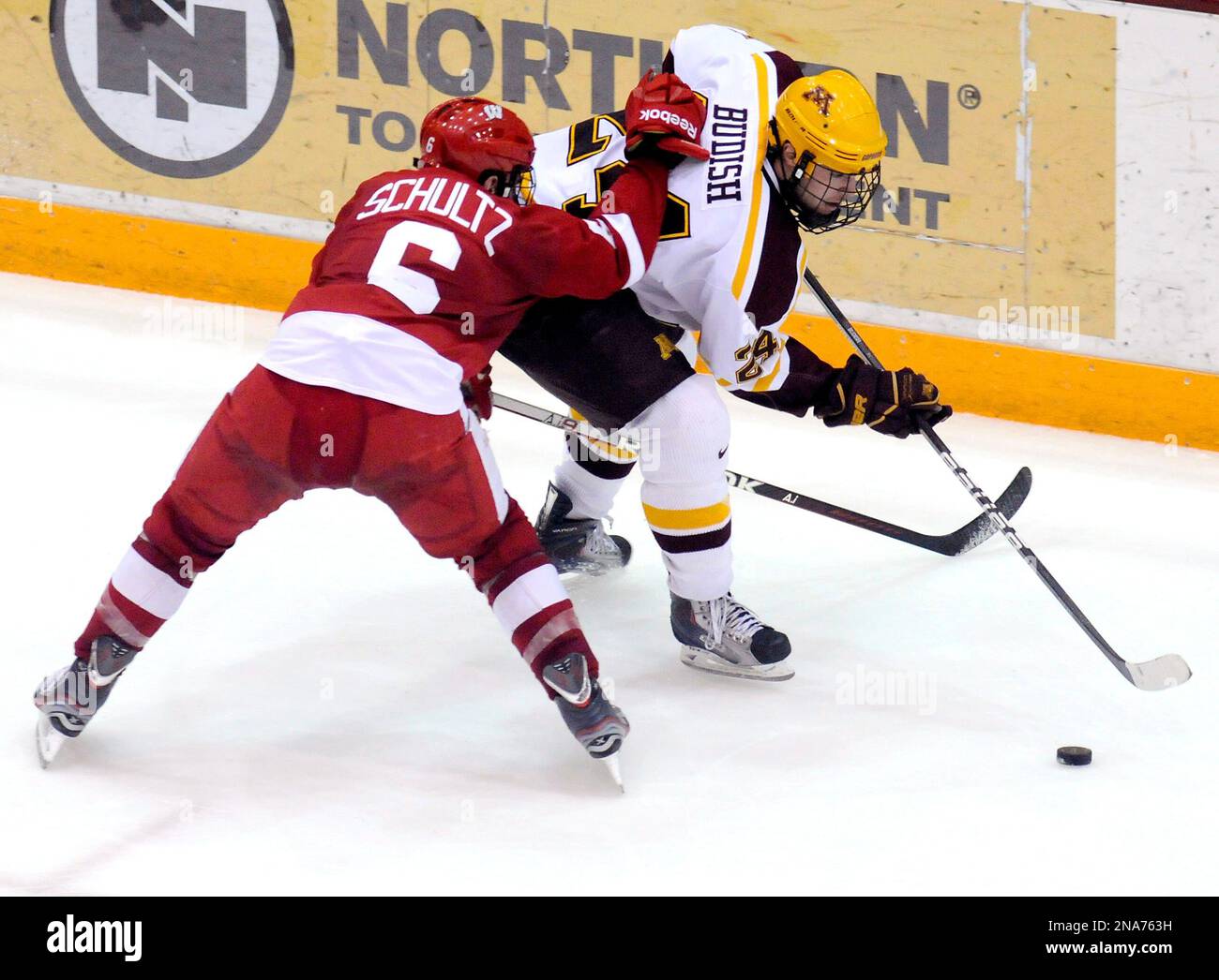 Wisconsin's Justin Schultz and Minnesota's Zach Budish chase the puck ...