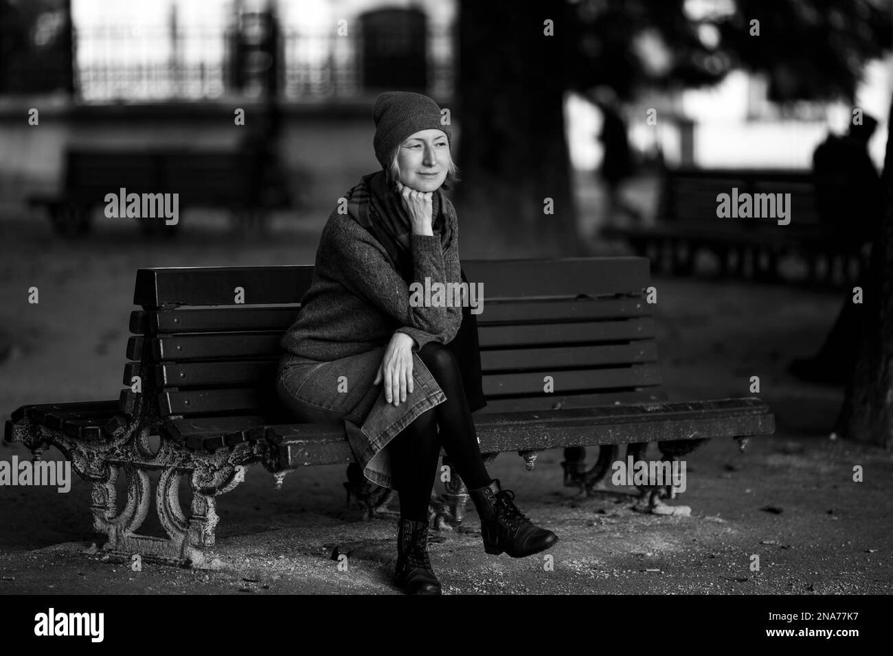 A woman sitting on a park bench. Black and white photograph Stock Photo ...