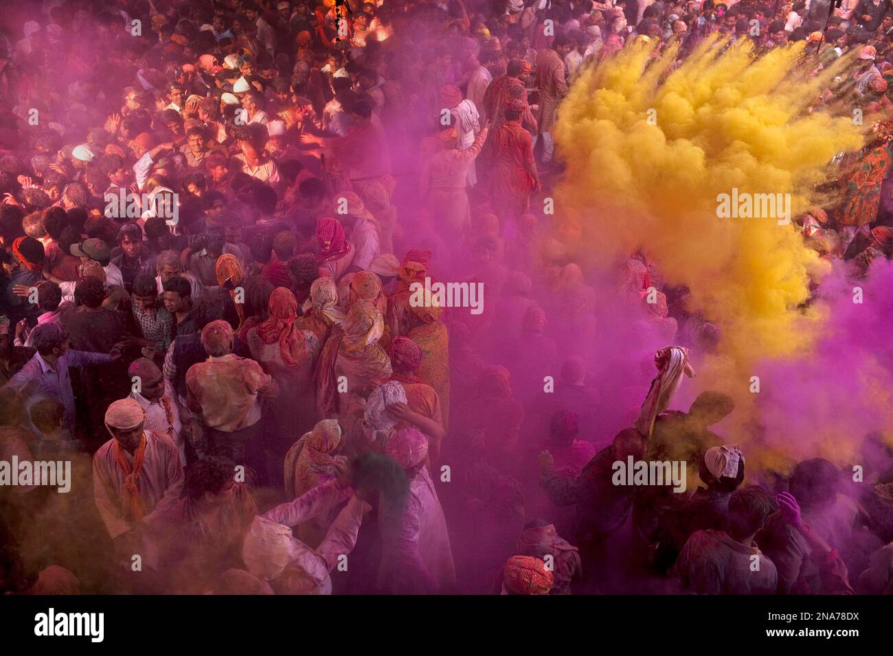 Indian Hindus worshippers are covered in colorful powder thrown on them ...