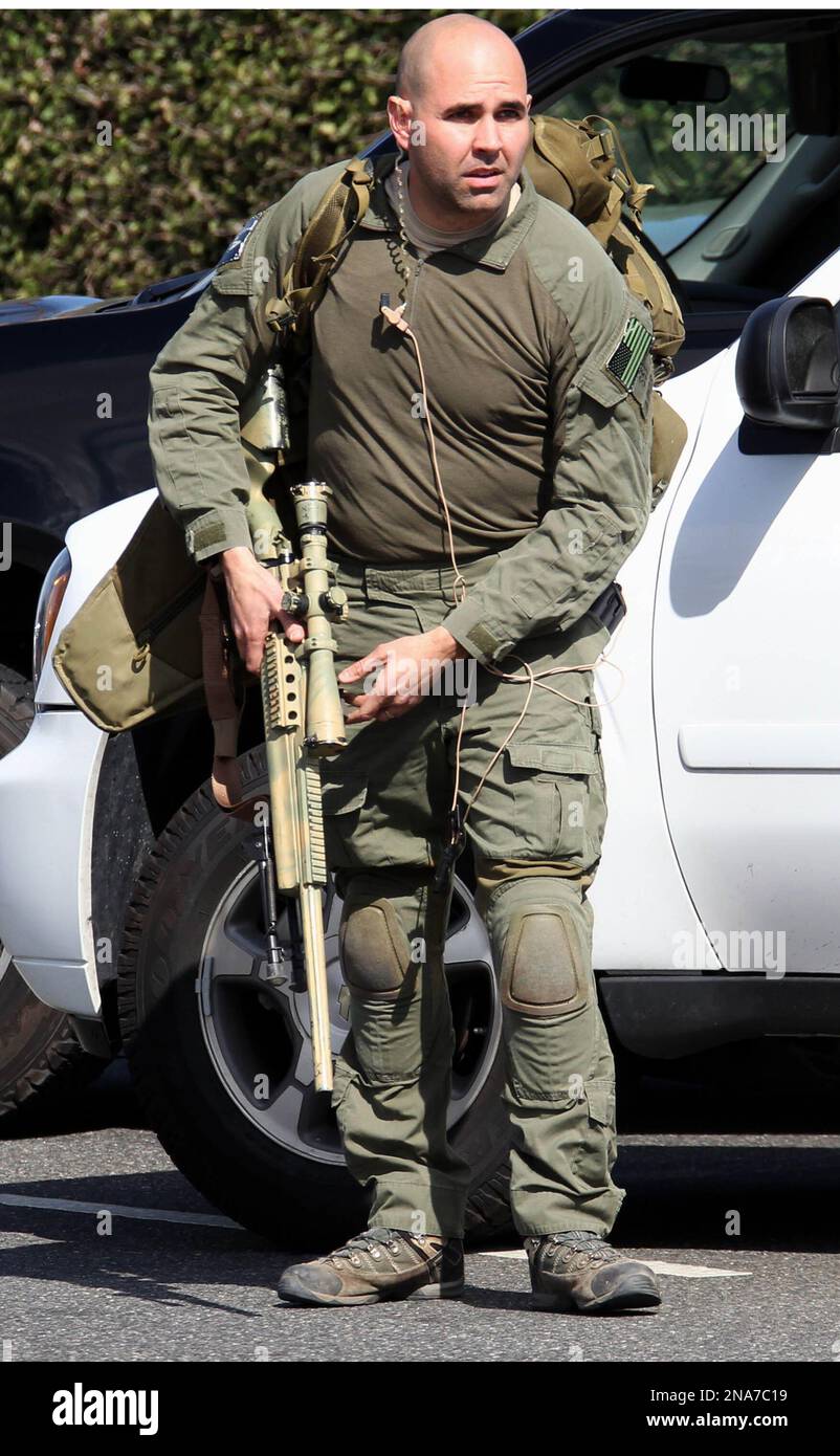 An FBI SWAT member holds a sniper rifle near the perimeter of a bank ...
