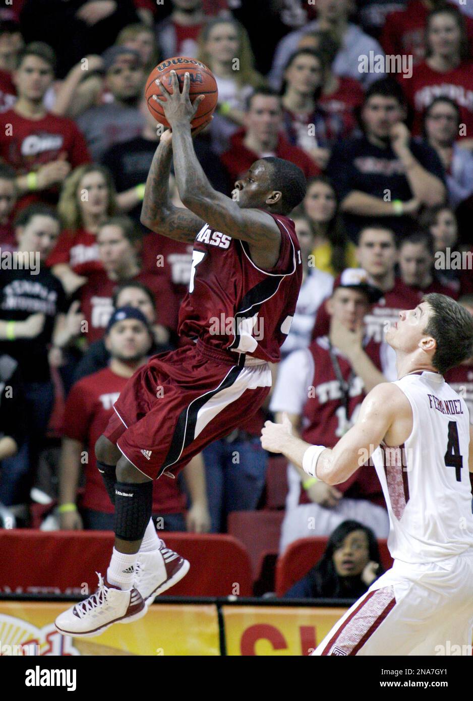 Massachusetts' Chaz Williams, left, shoots in front of Temple's Juan ...