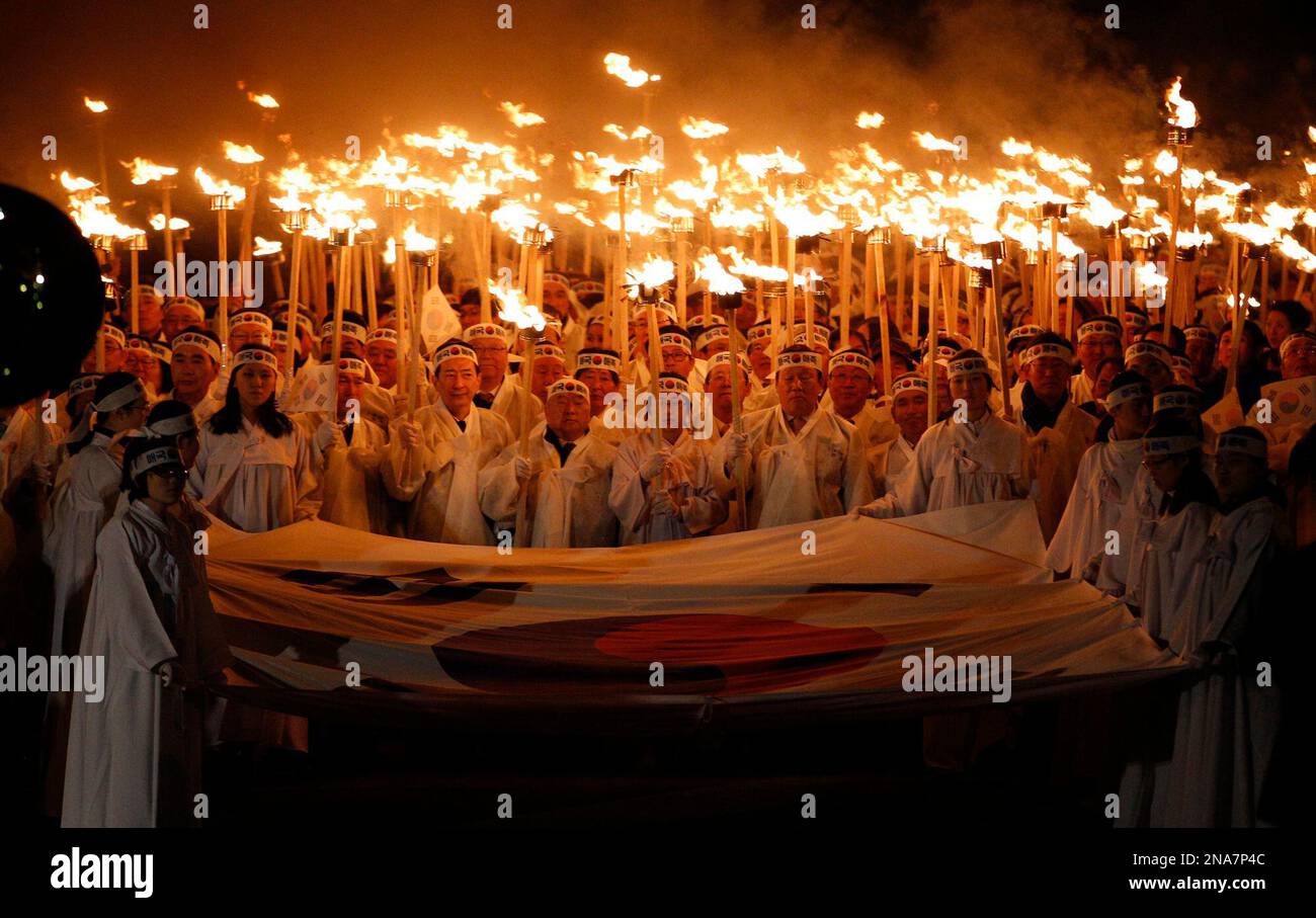 South Koreans wearing traditional Korean costumes carry torches in ...