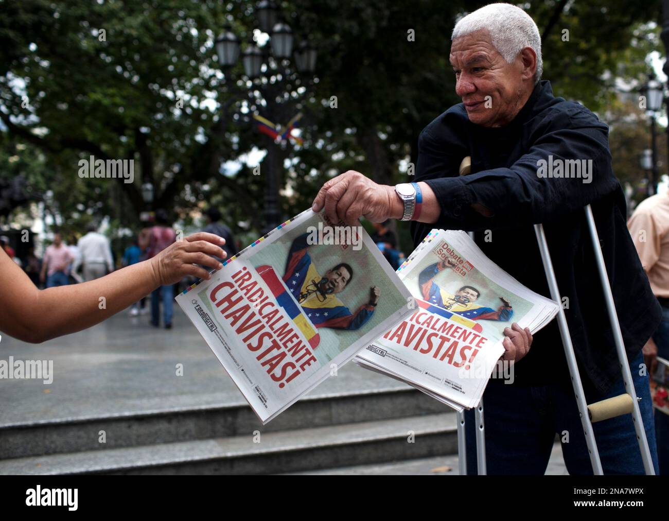 A man hands out government flyers with a front page image of Venezuela ...