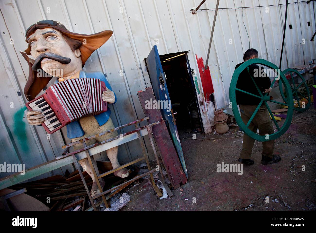 An Israeli worker puts a final touch on colorful float to be used next ...