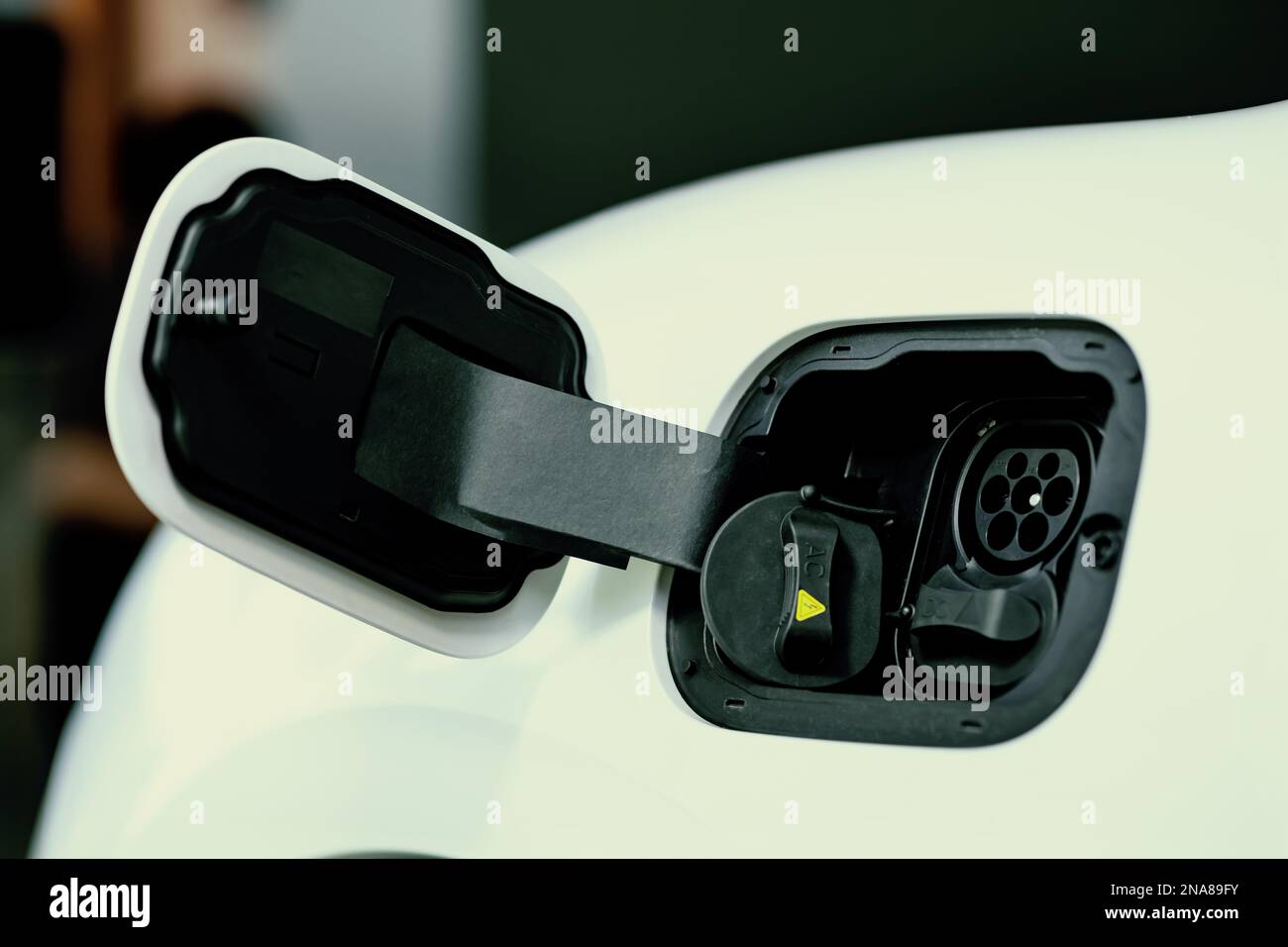 Closeup electric vehicle plugged-in with cable from charging point ...