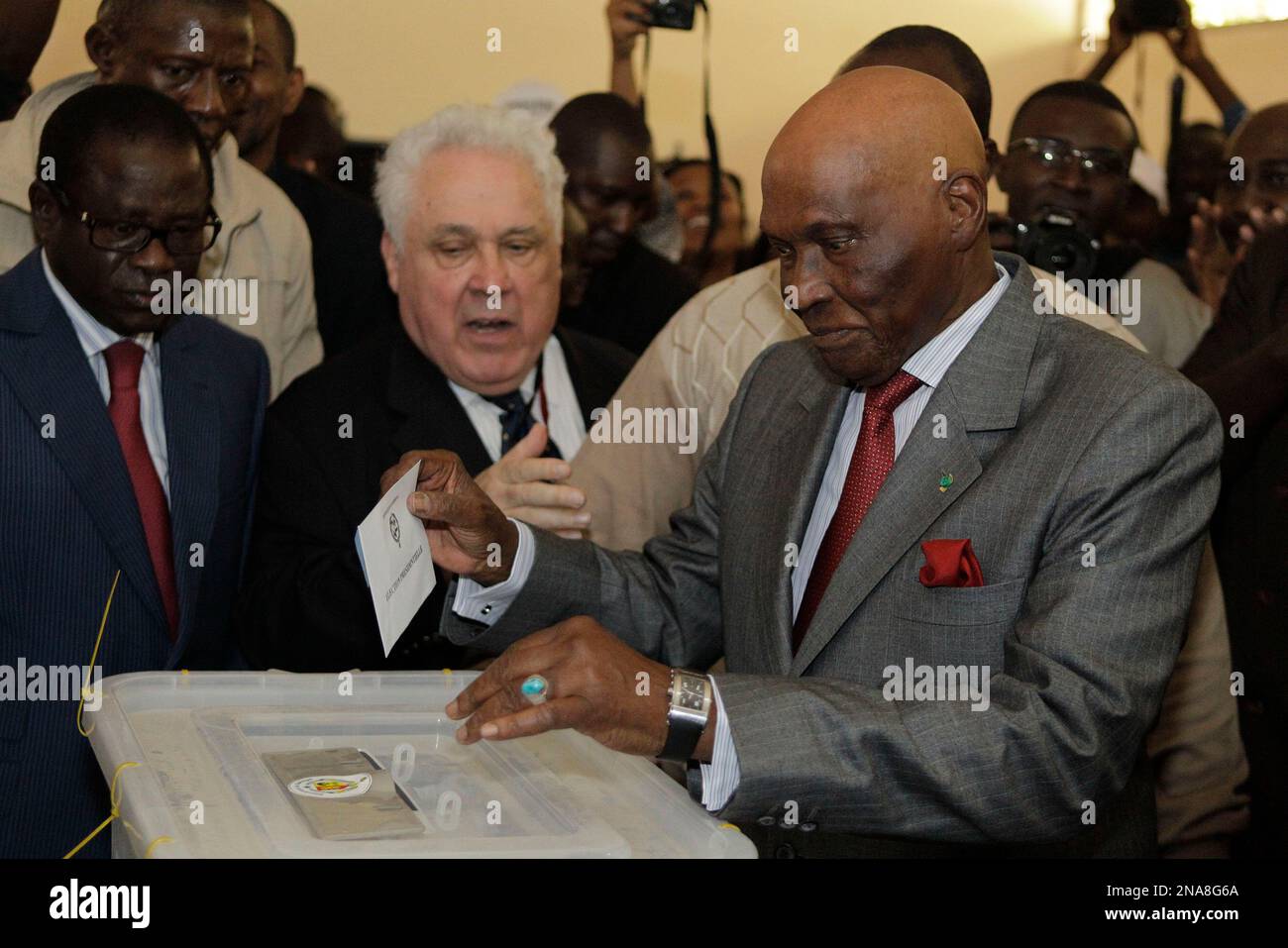 Senegalese President Abdoulaye Wade, right, casts his vote in presidential elections, in his ...