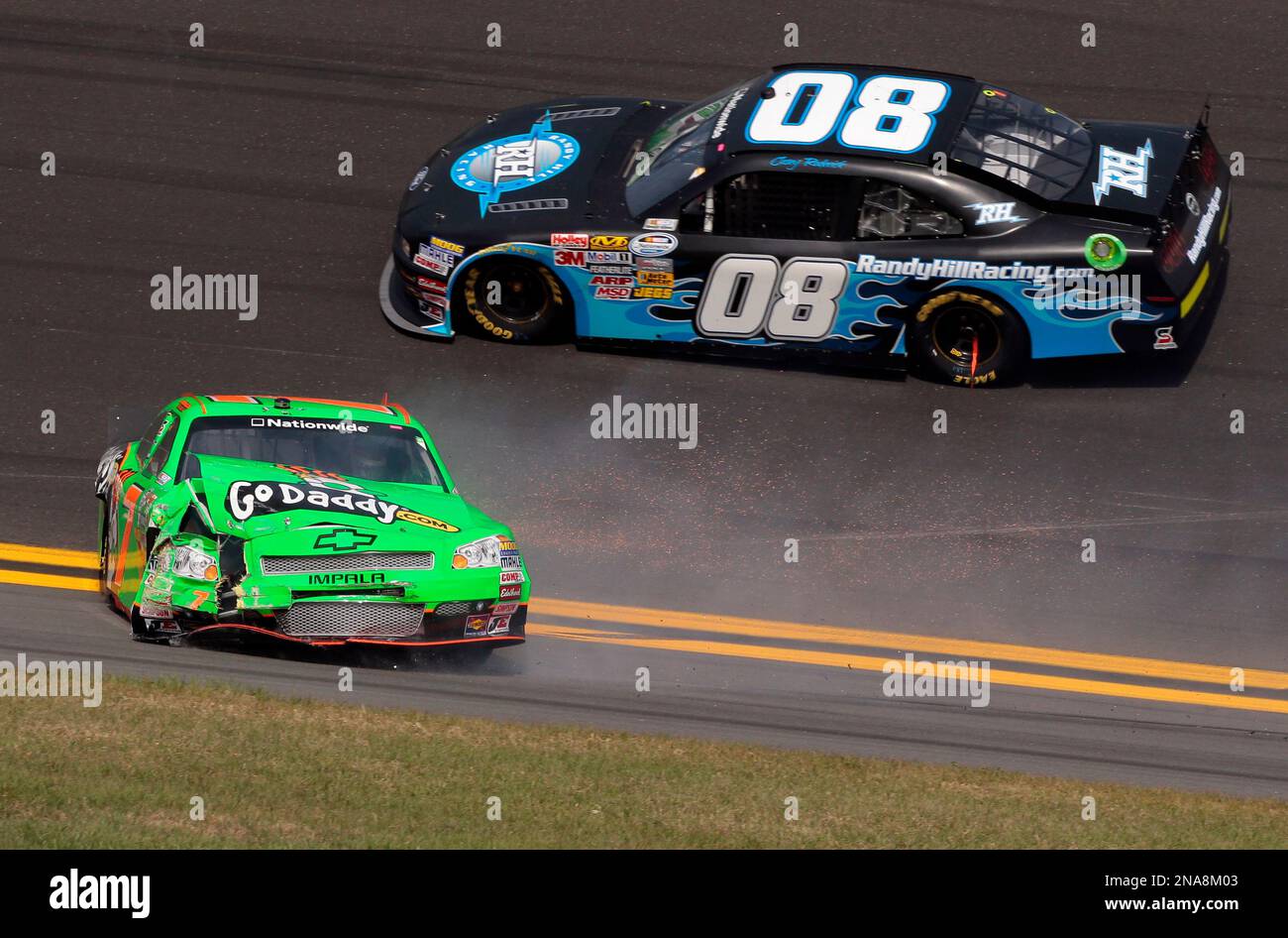Driver Danica Patrick, left, slides down the track after a crash as ...