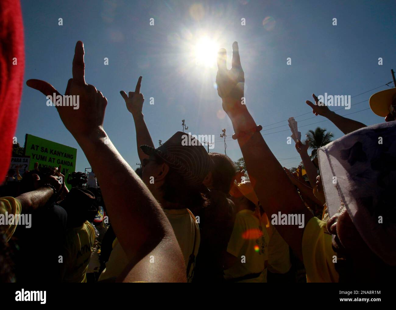 People flash the "L" sign (for Laban, meaning Fight!) as they sing a ...
