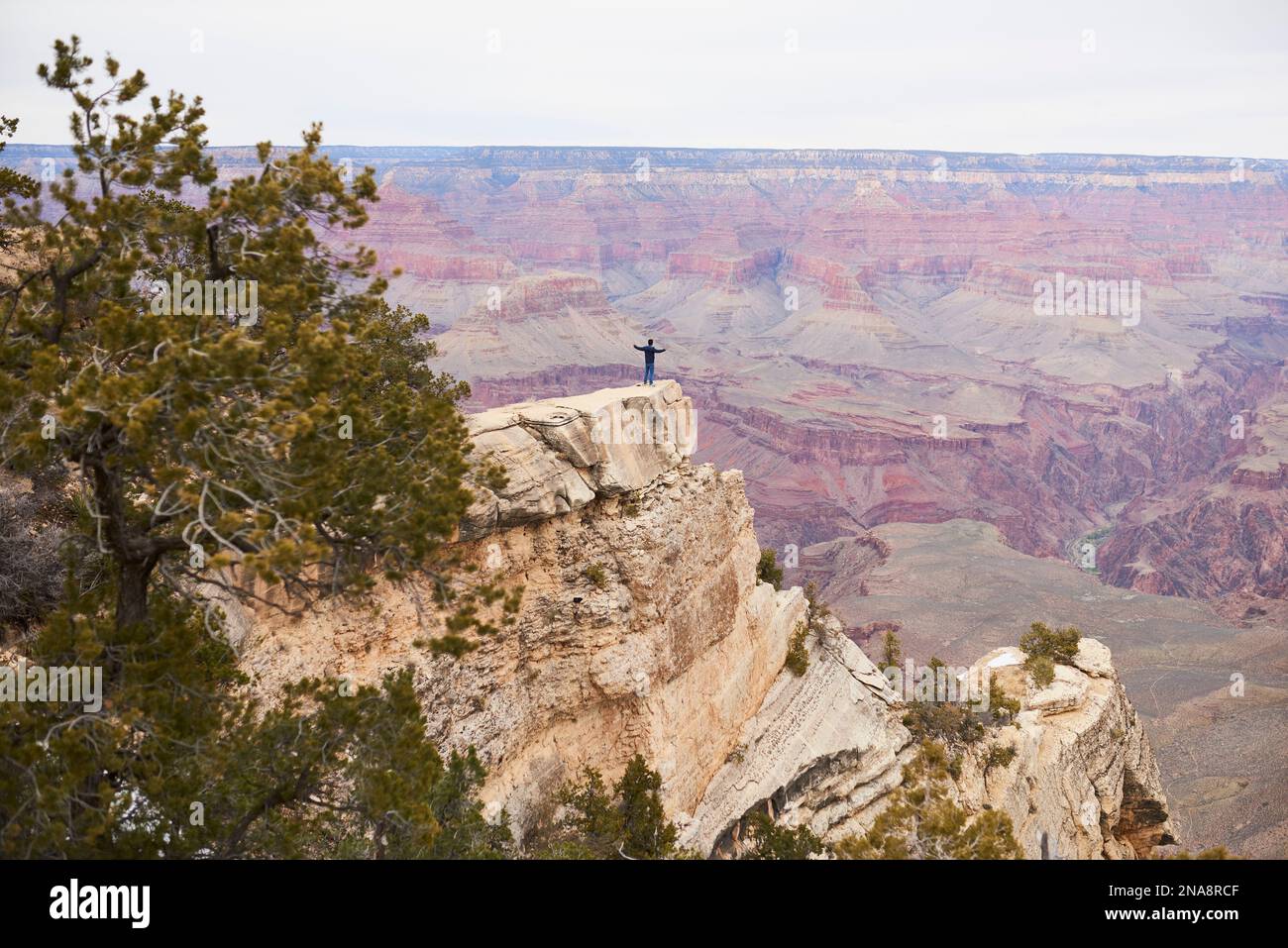 Wide angle landscape of tourist with arms raised being photographed on ...
