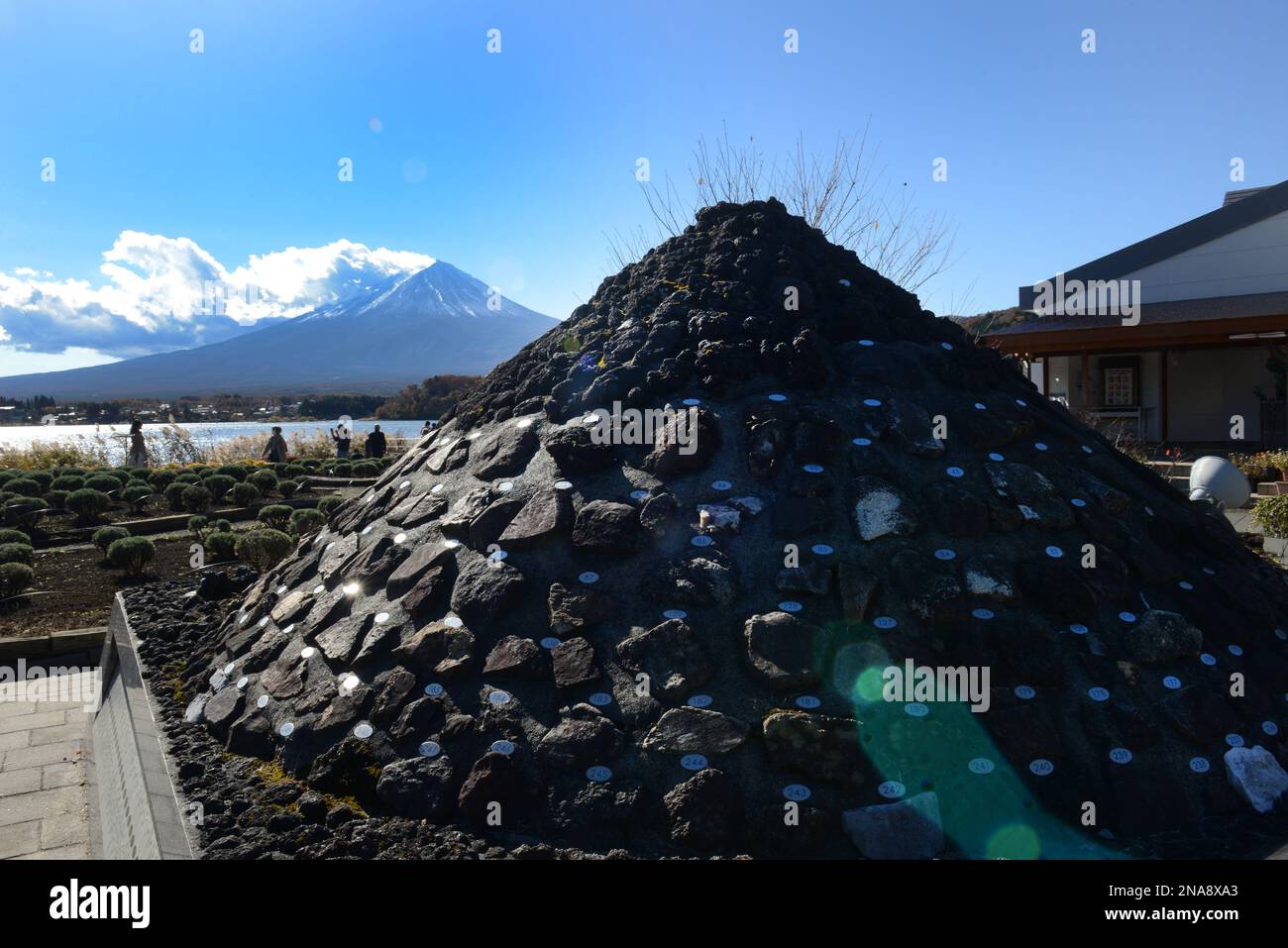 A model of Mount Fuji with Mt. Fuji in the background at the Oishi park ...