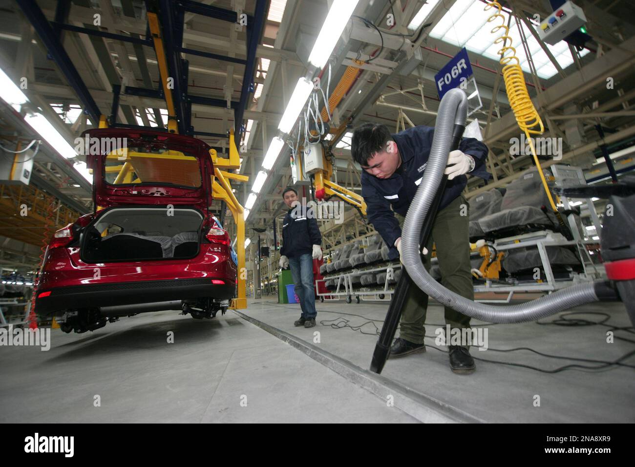 A Chinese worker cleans assembly line of the cars at a newly opened ...
