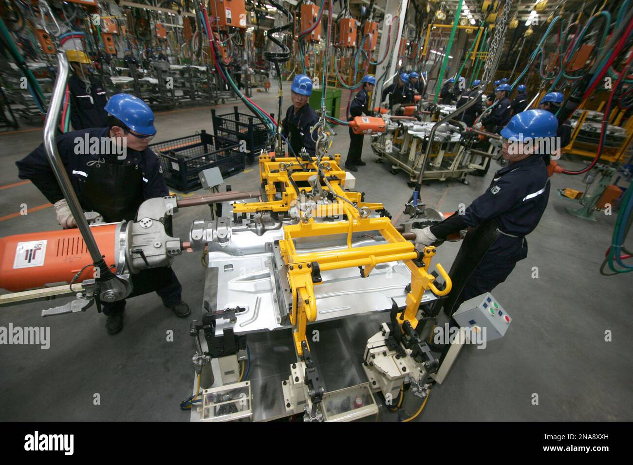 Chinese workers assemble the parts of cars at newly opened Changan Ford ...