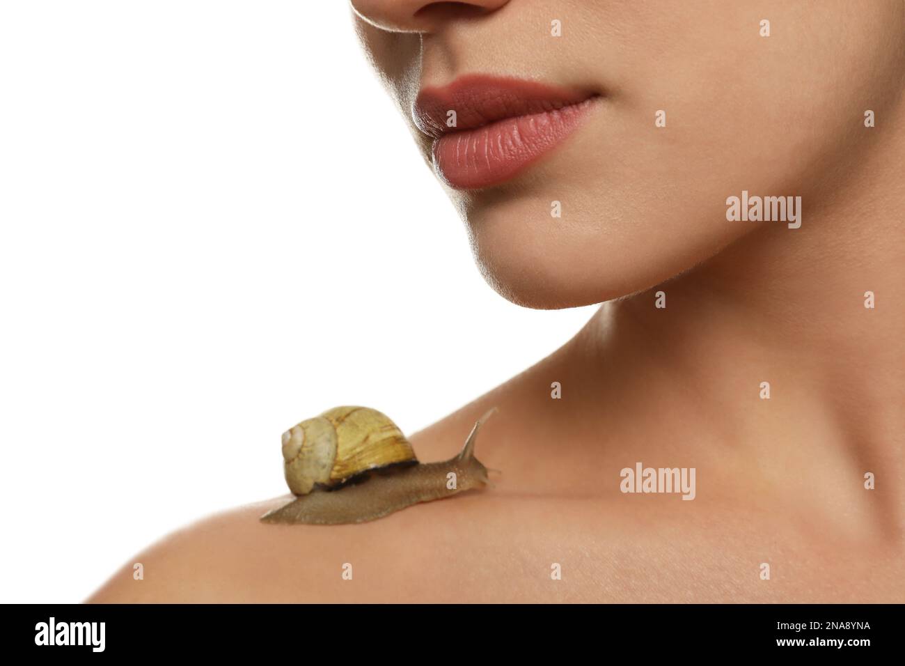 Beautiful young woman with snail on her body against white background ...