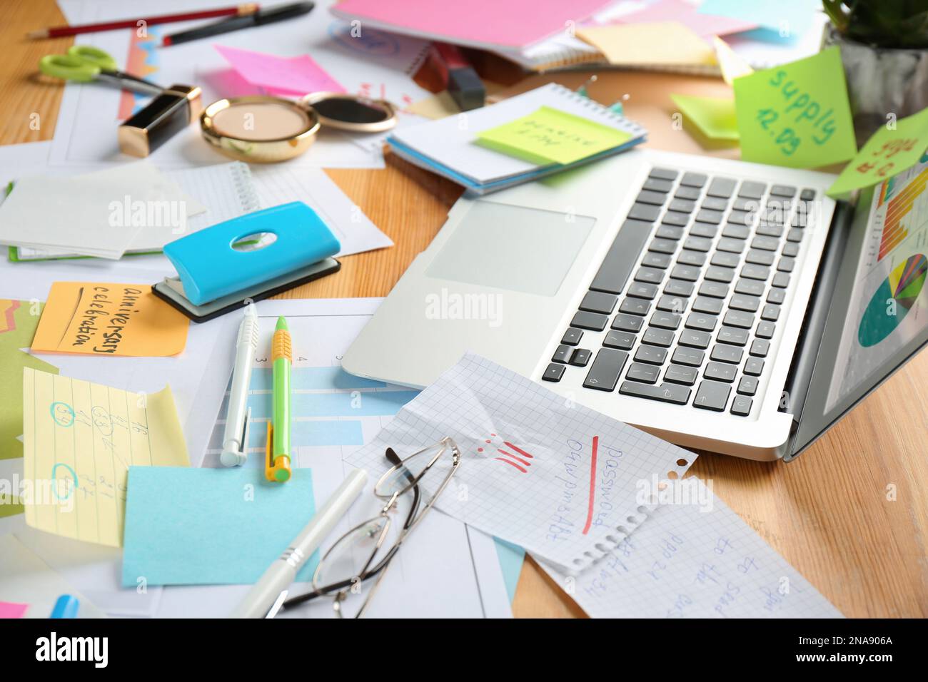 Messy table with laptop and stationery. Concept of being overwhelmed by ...