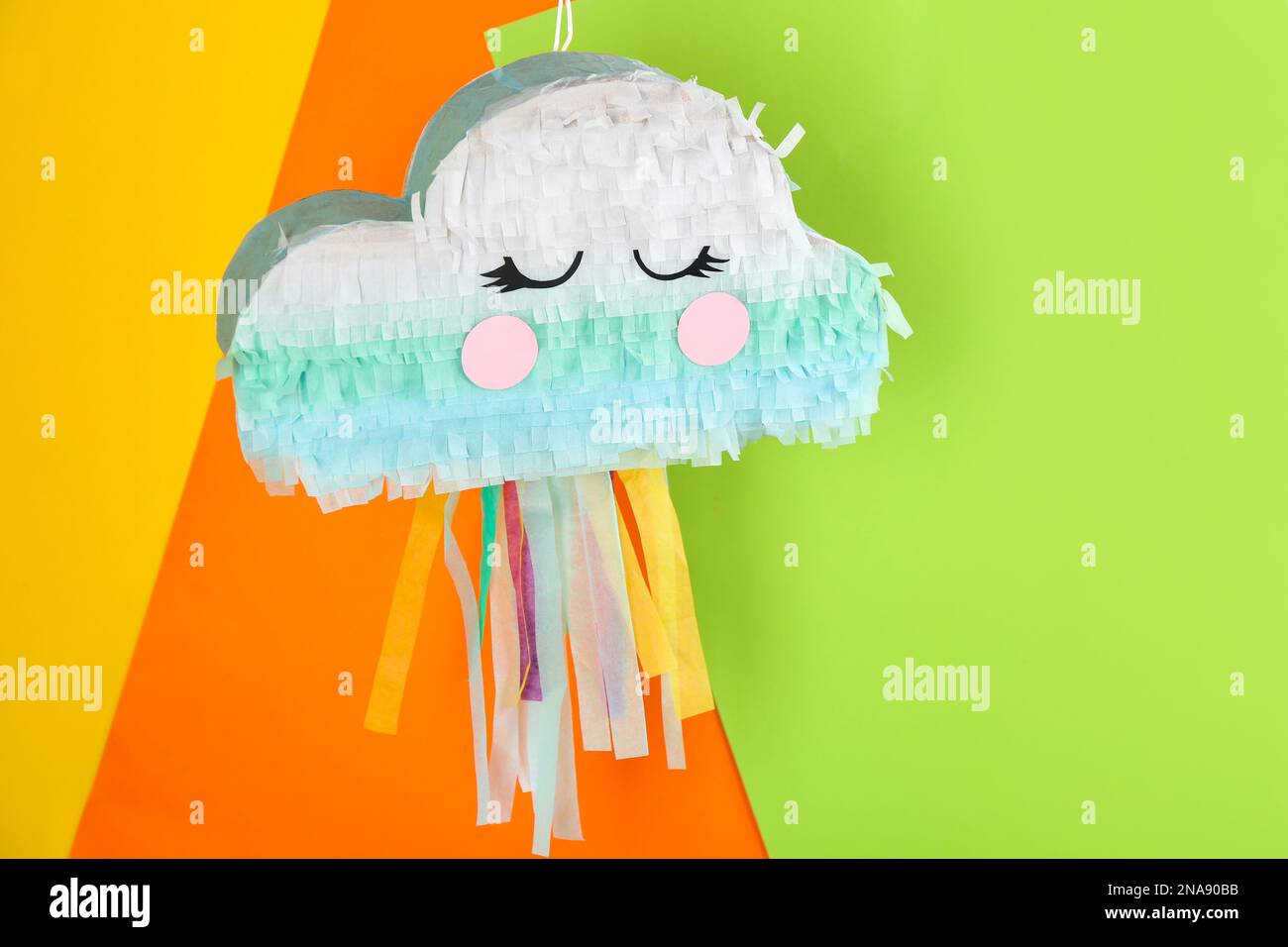 Cloud shaped pinata hanging on color background Stock Photo - Alamy