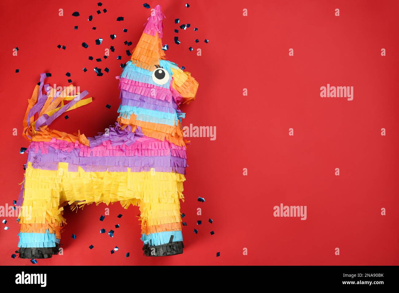 Bright donkey pinata and confetti on background, flat lay. Space for ...