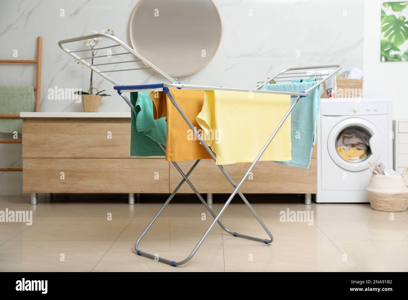 Clean laundry hanging on drying rack in bathroom Stock Photo - Alamy