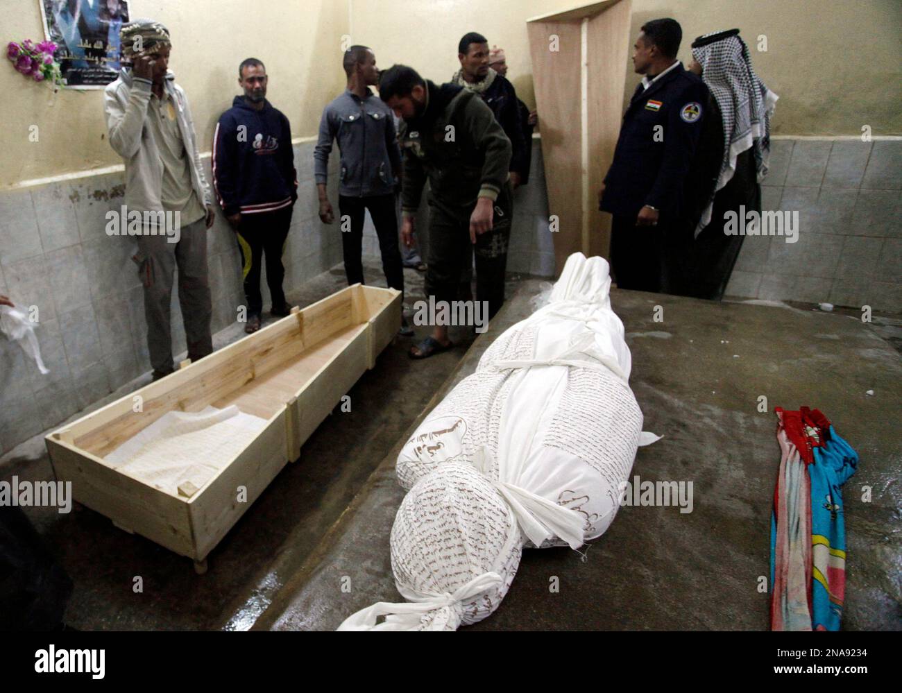 Family members gather around the body of 35-year-old Ahmed Abdul Rahman ...