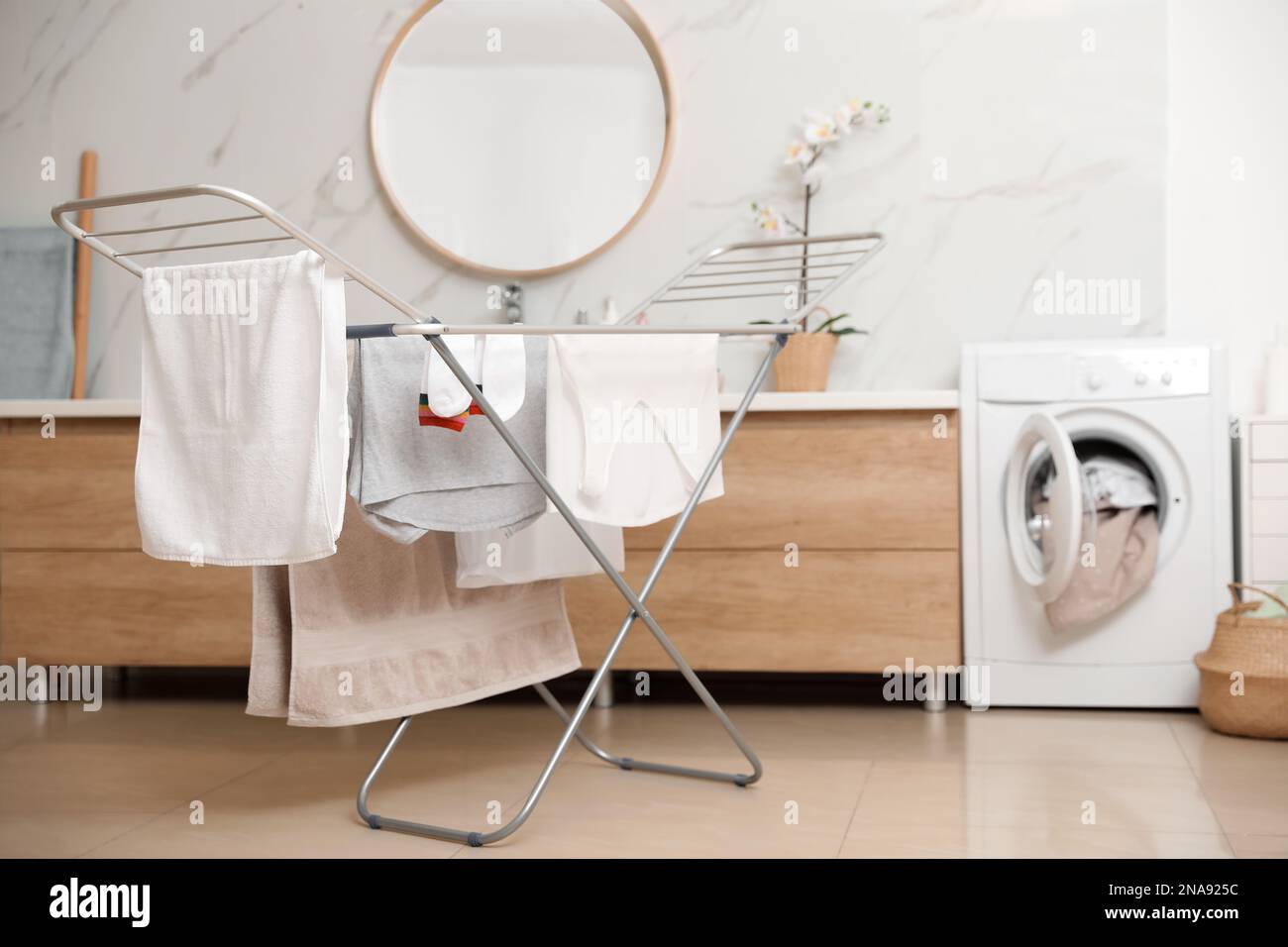 Clean laundry hanging on drying rack in bathroom. Space for text Stock ...