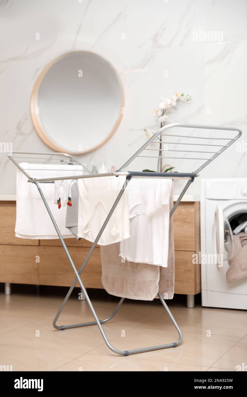 Clean laundry hanging on drying rack in bathroom Stock Photo - Alamy