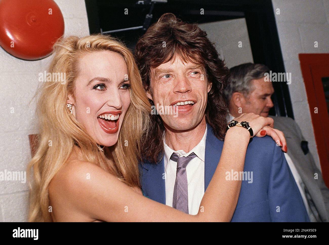 Singer Mick Jagger clowns around with girlfriend Jerry Hall backstage ...