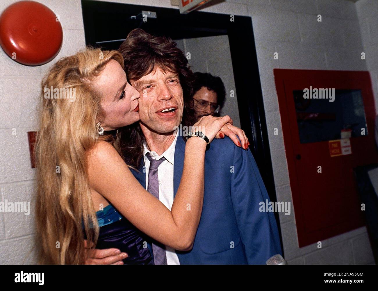 Singer Mick Jagger clowns is kissed by girlfriend Jerry Hall backstage ...