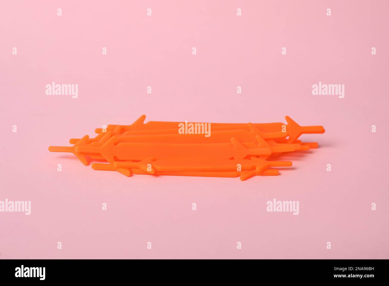 Orange silicone shoe laces on light pink background Stock Photo - Alamy