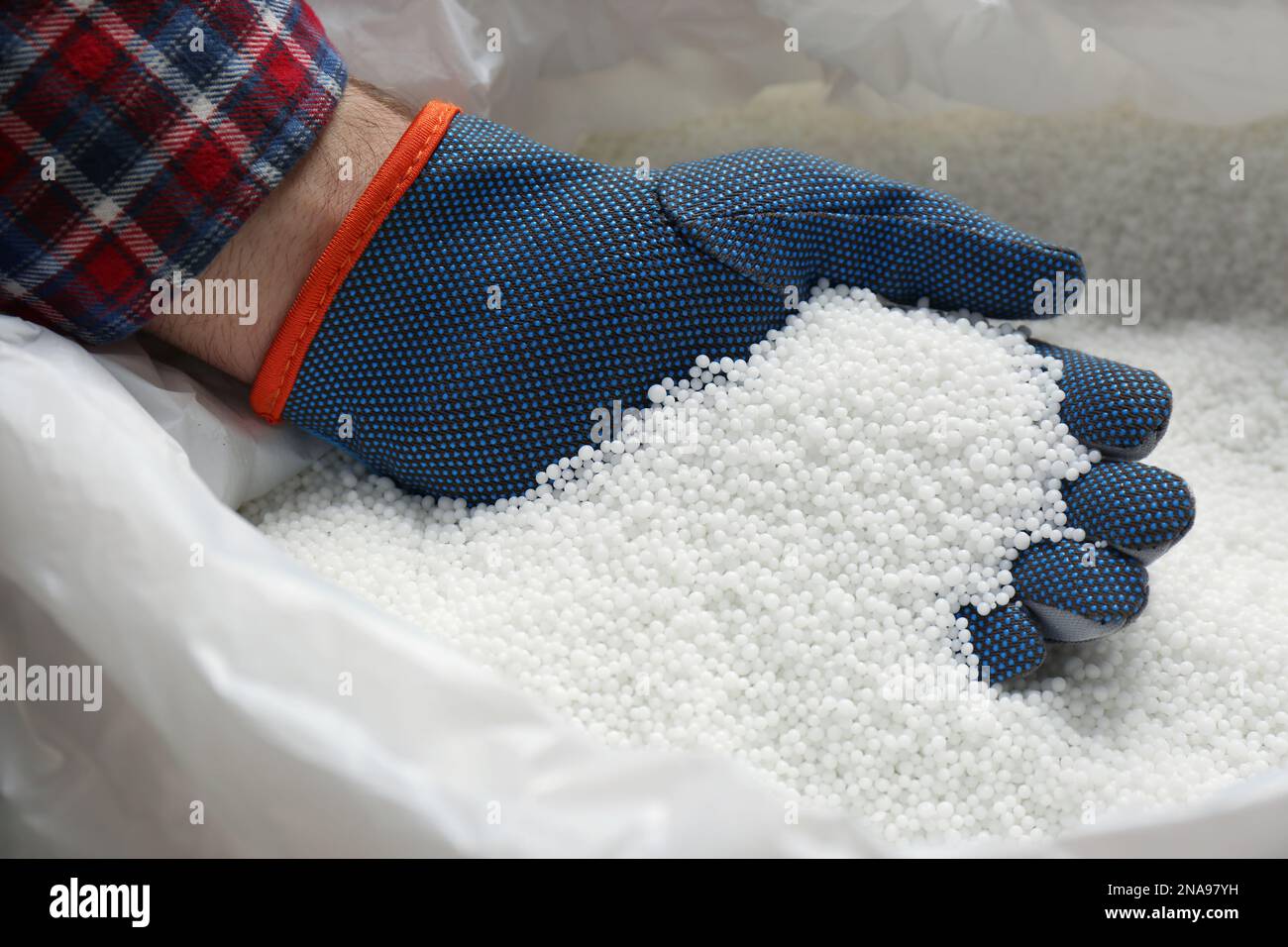 Farmer taking pellets of ammonium nitrate from bag, closeup. Mineral ...