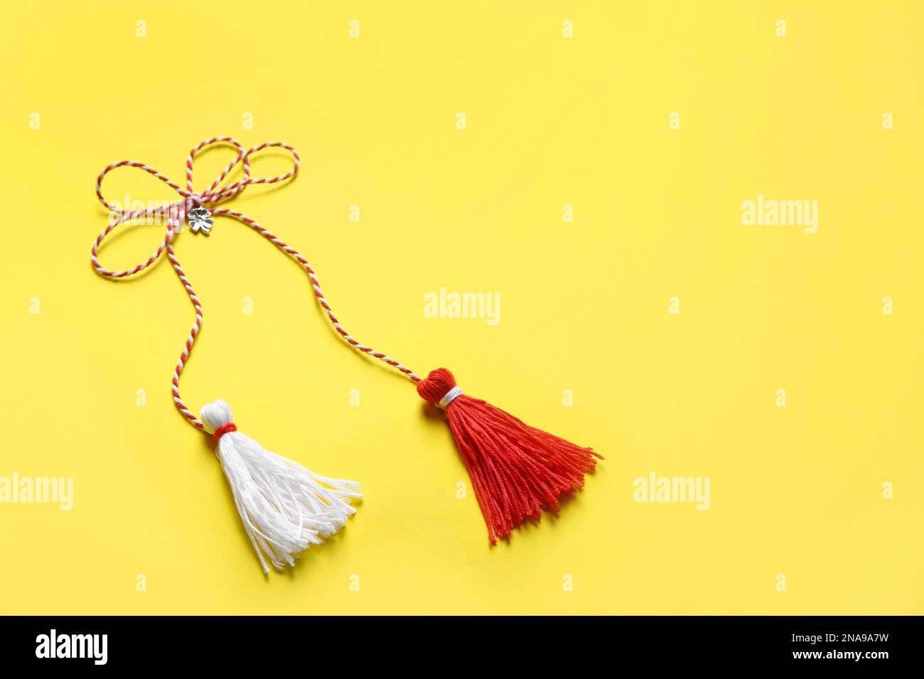 Traditional martisor on yellow background, space for text. Beginning of ...