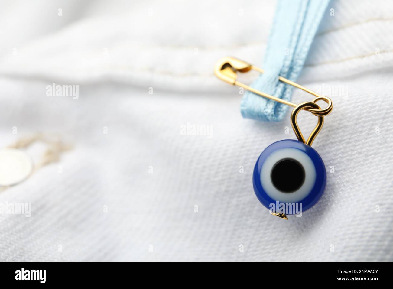 Evil eye safety pin on clothing, closeup Stock Photo - Alamy