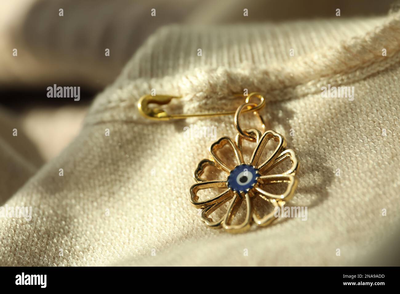 Evil eye safety pin on clothing, closeup Stock Photo - Alamy