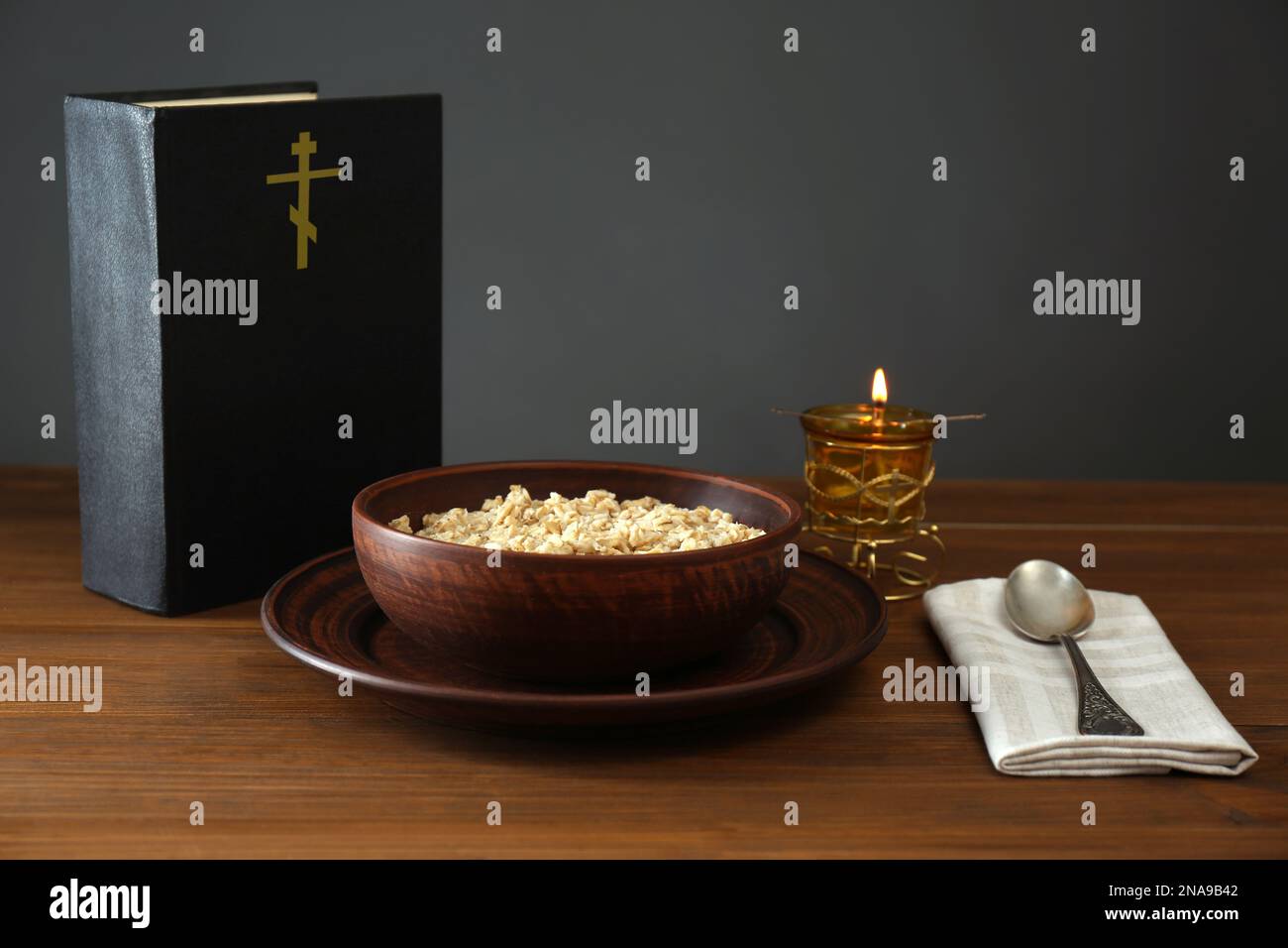 Bible, oatmeal porridge and spoon on wooden table. Lent season Stock ...