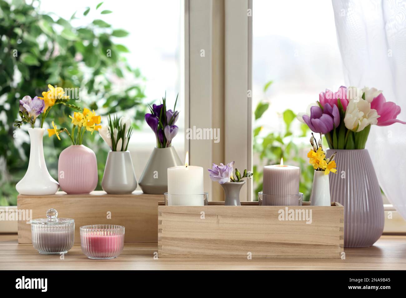 Beautiful spring flowers with burning candles on window sill Stock ...