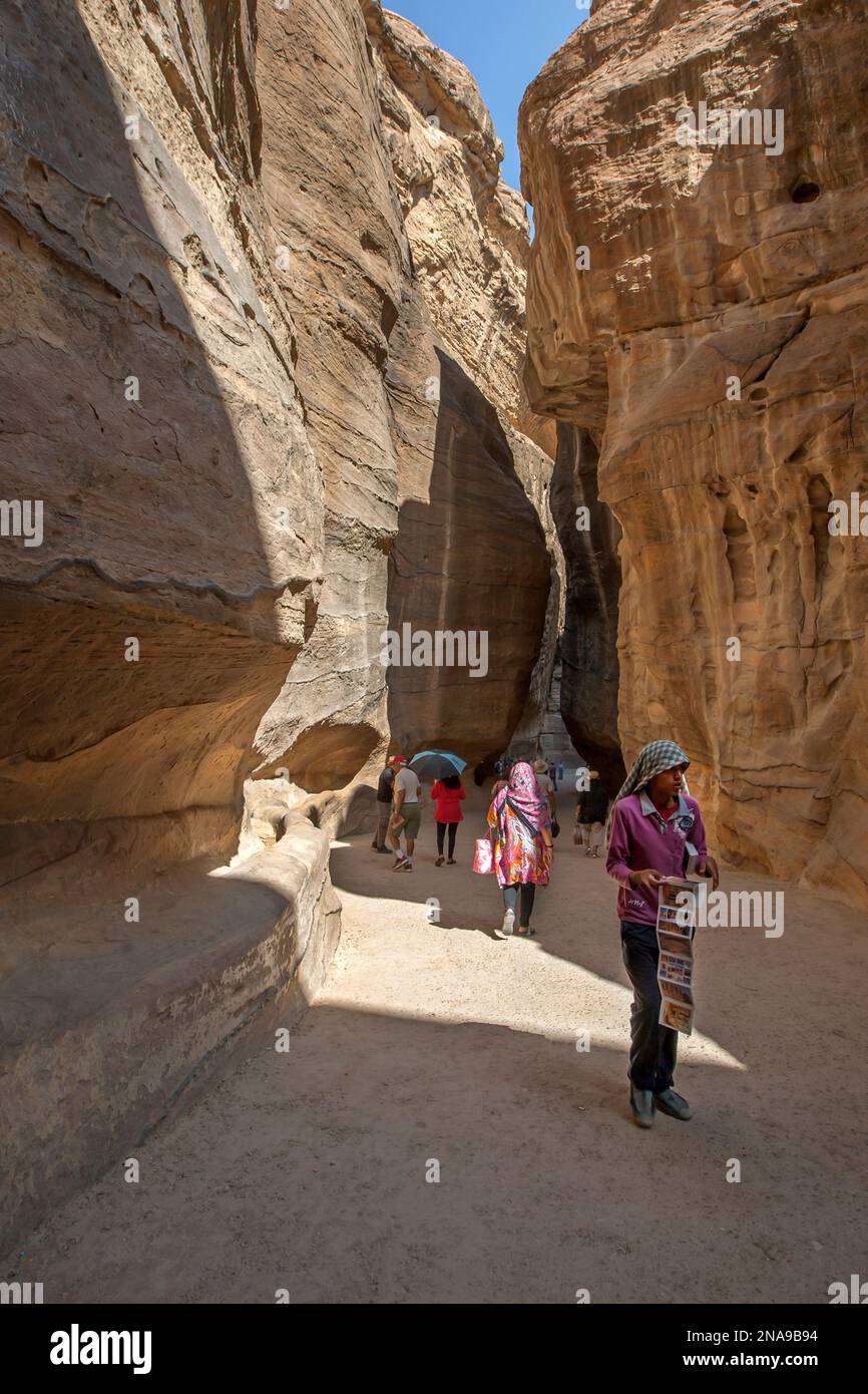 A Bedouin boy selling postcards within the Siq at the ancient site of ...