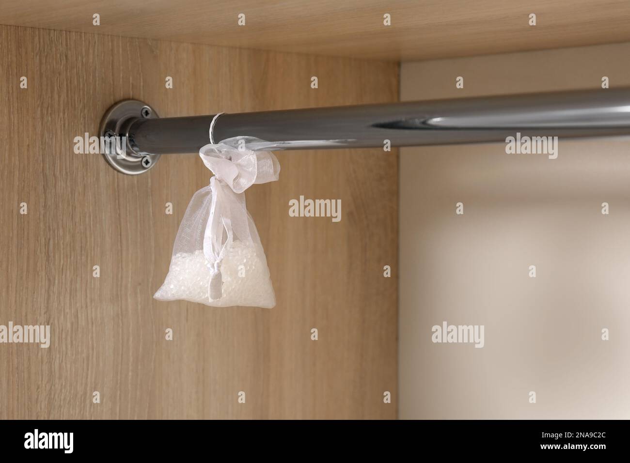 Scented sachet hanging on metal bar in wardrobe Stock Photo - Alamy