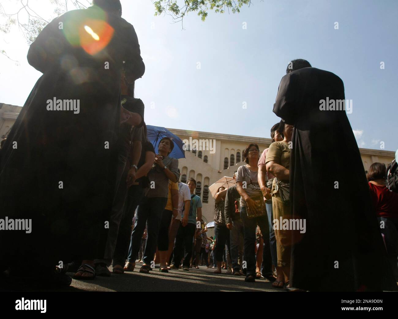 Catholic priests mark the foreheads of devotees with black ashes in the ...