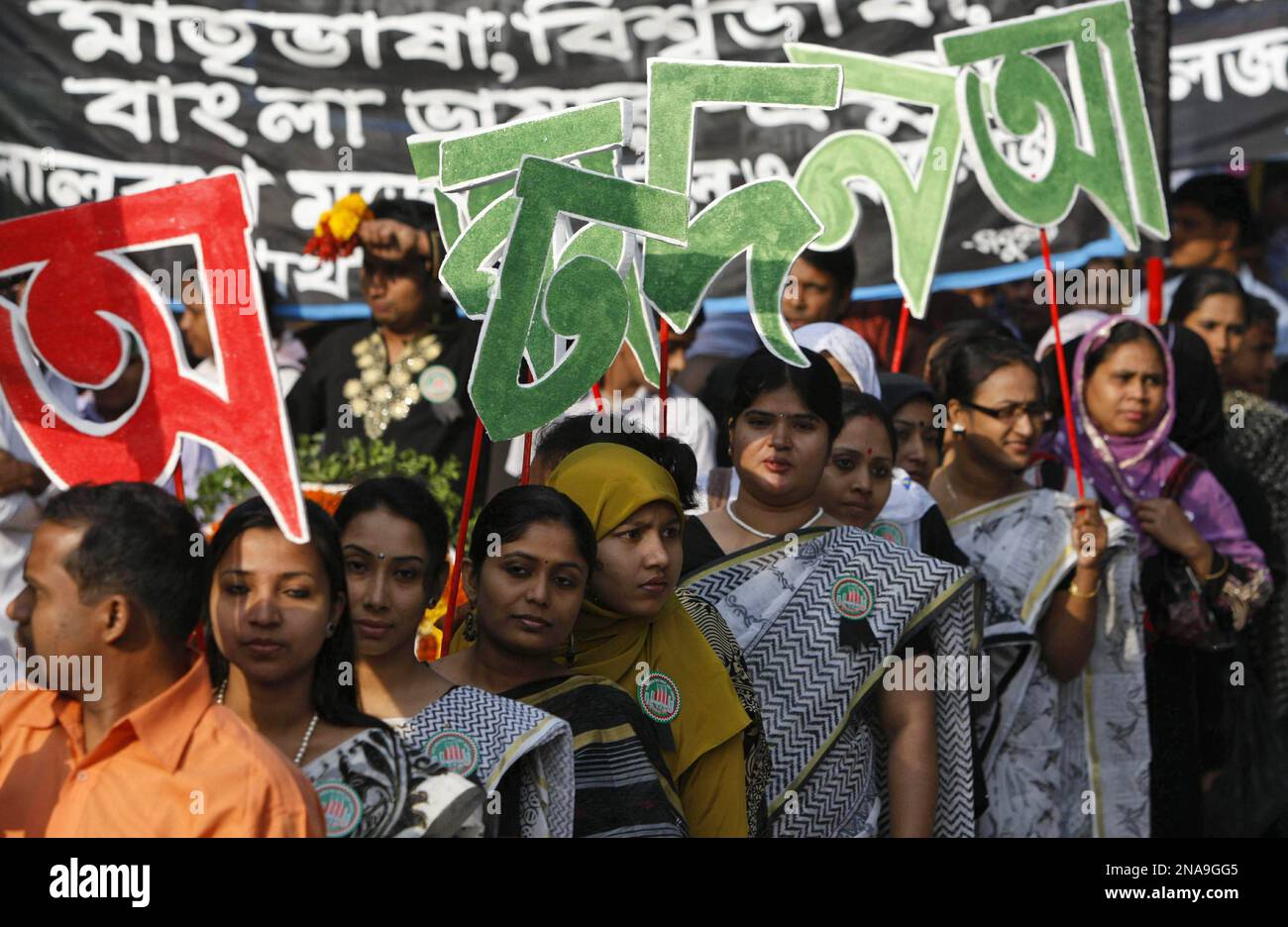 Bangladeshis hold letters of the Bangla language and participate in a ...