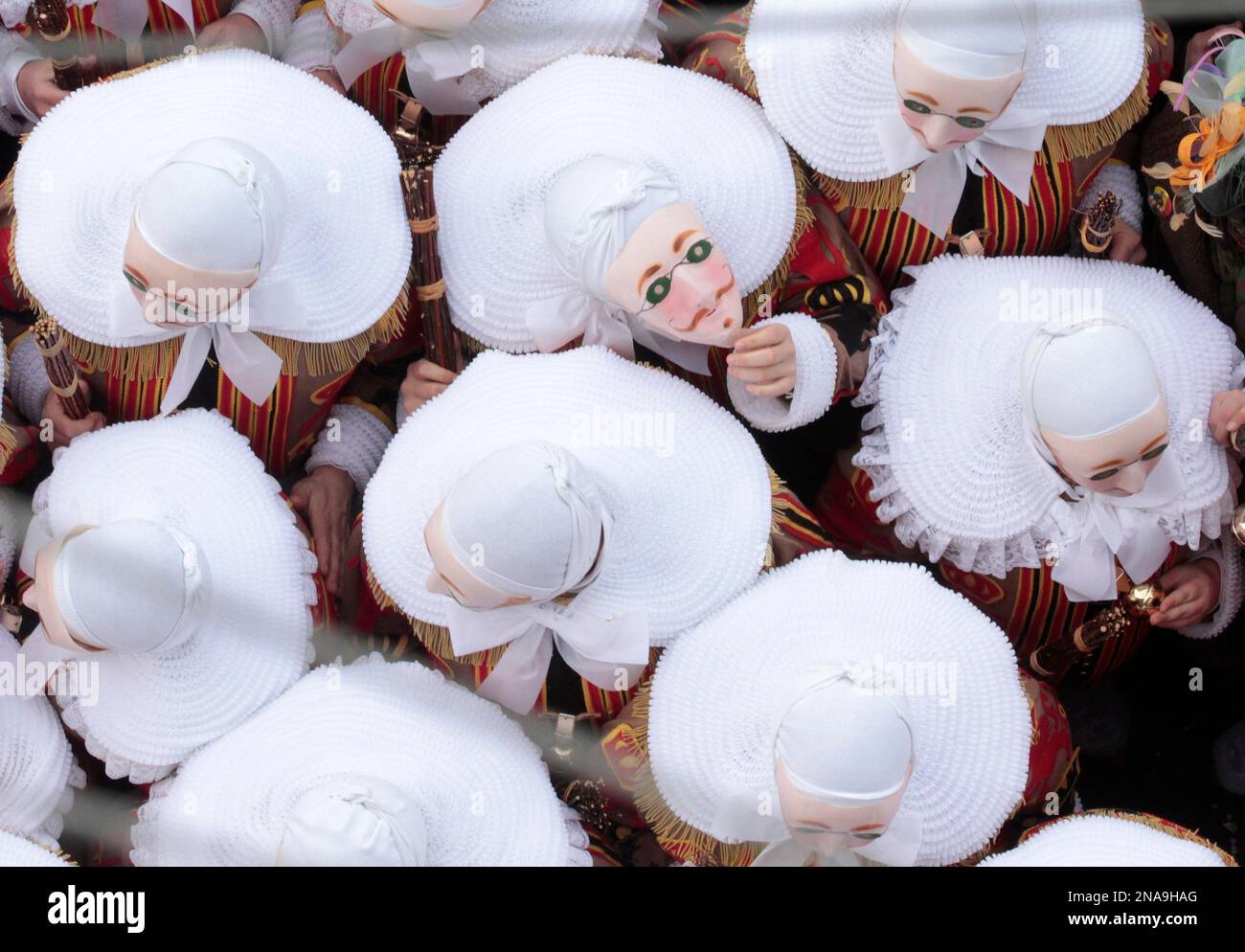 A 'Gille of Binche' shows his wax mask during a carnival parade in the ...