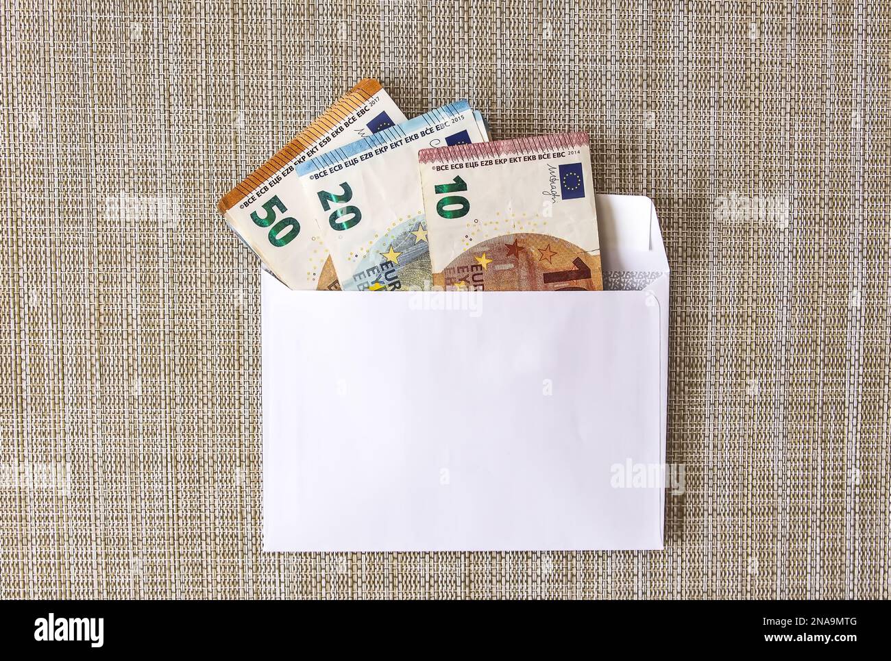 Euro money banknotes in the white paper envelope on a light background ...