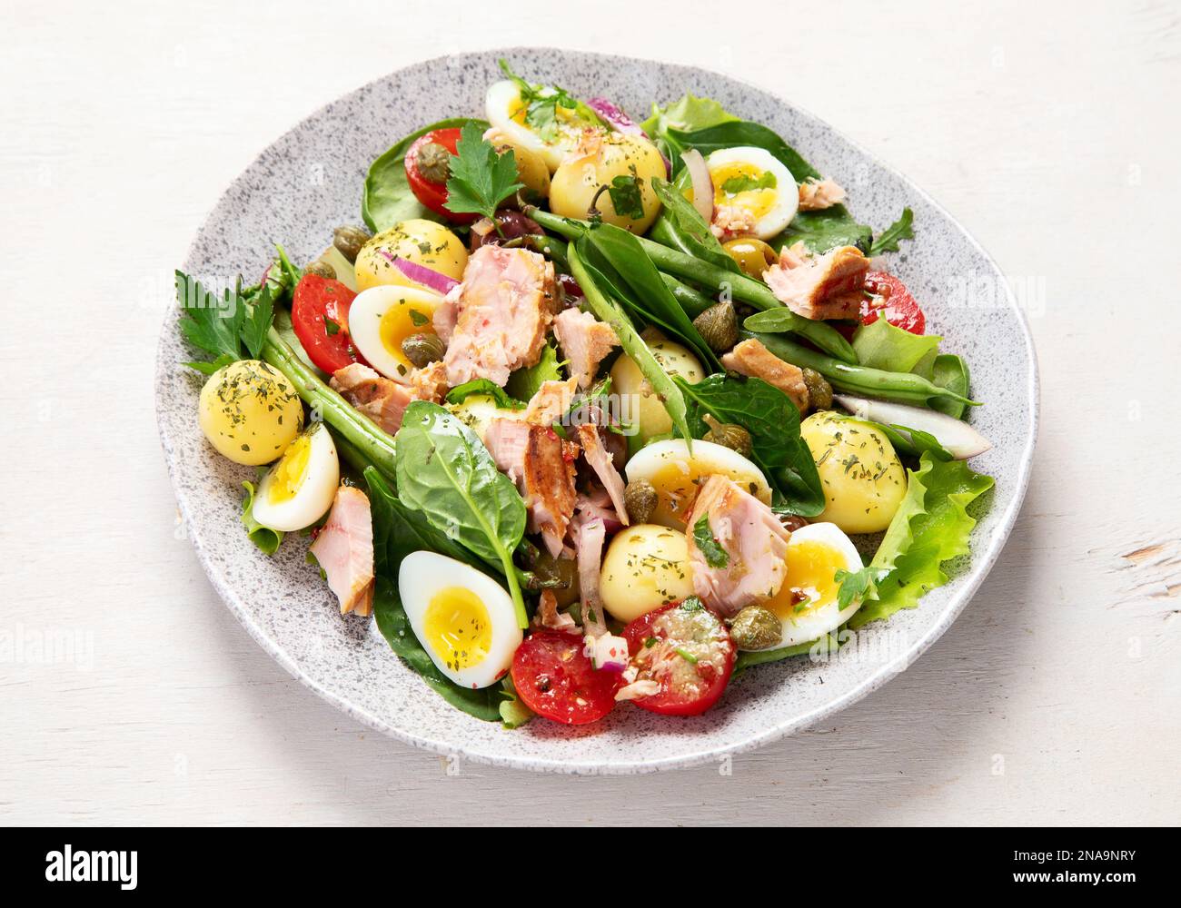 Nicoise salad, traditional French food on white background. Tuna salad ...