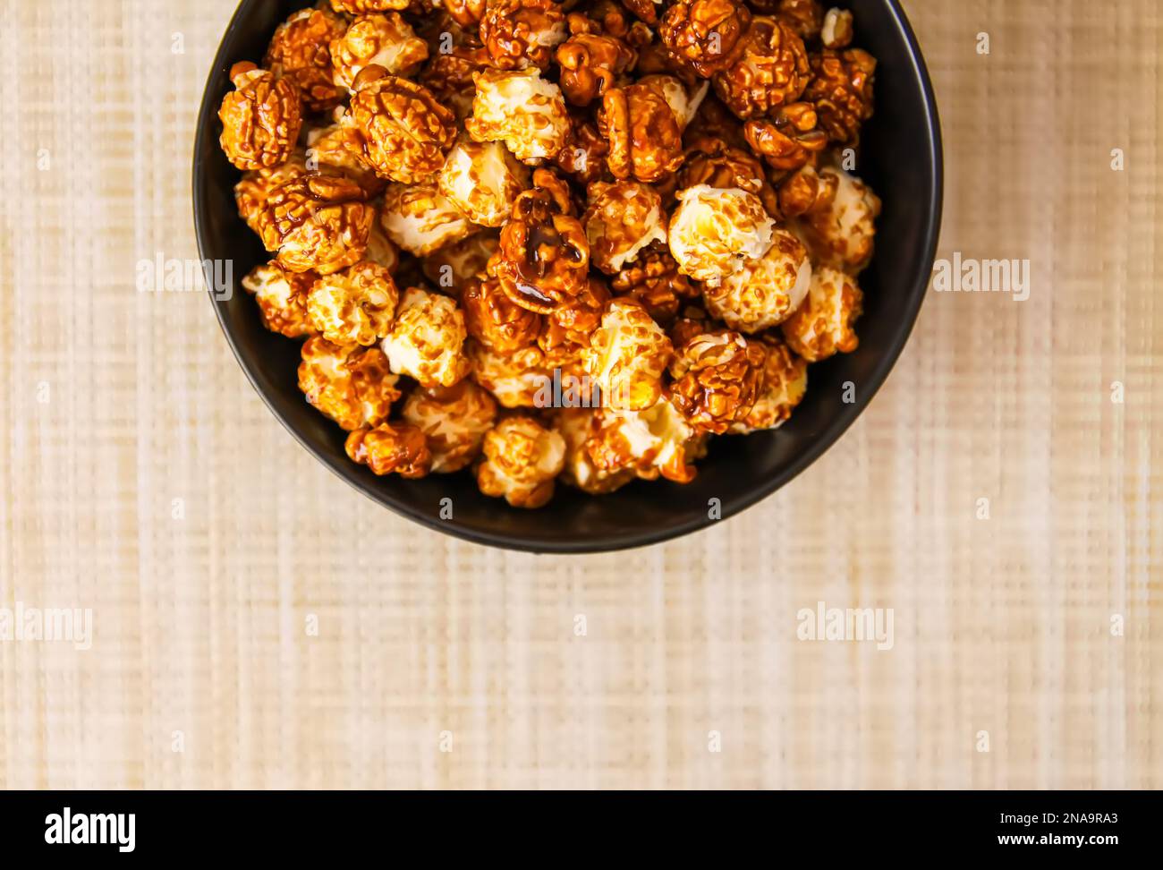 Sweet ready-to-eat popcorn in a black ceramic plate close up Stock ...