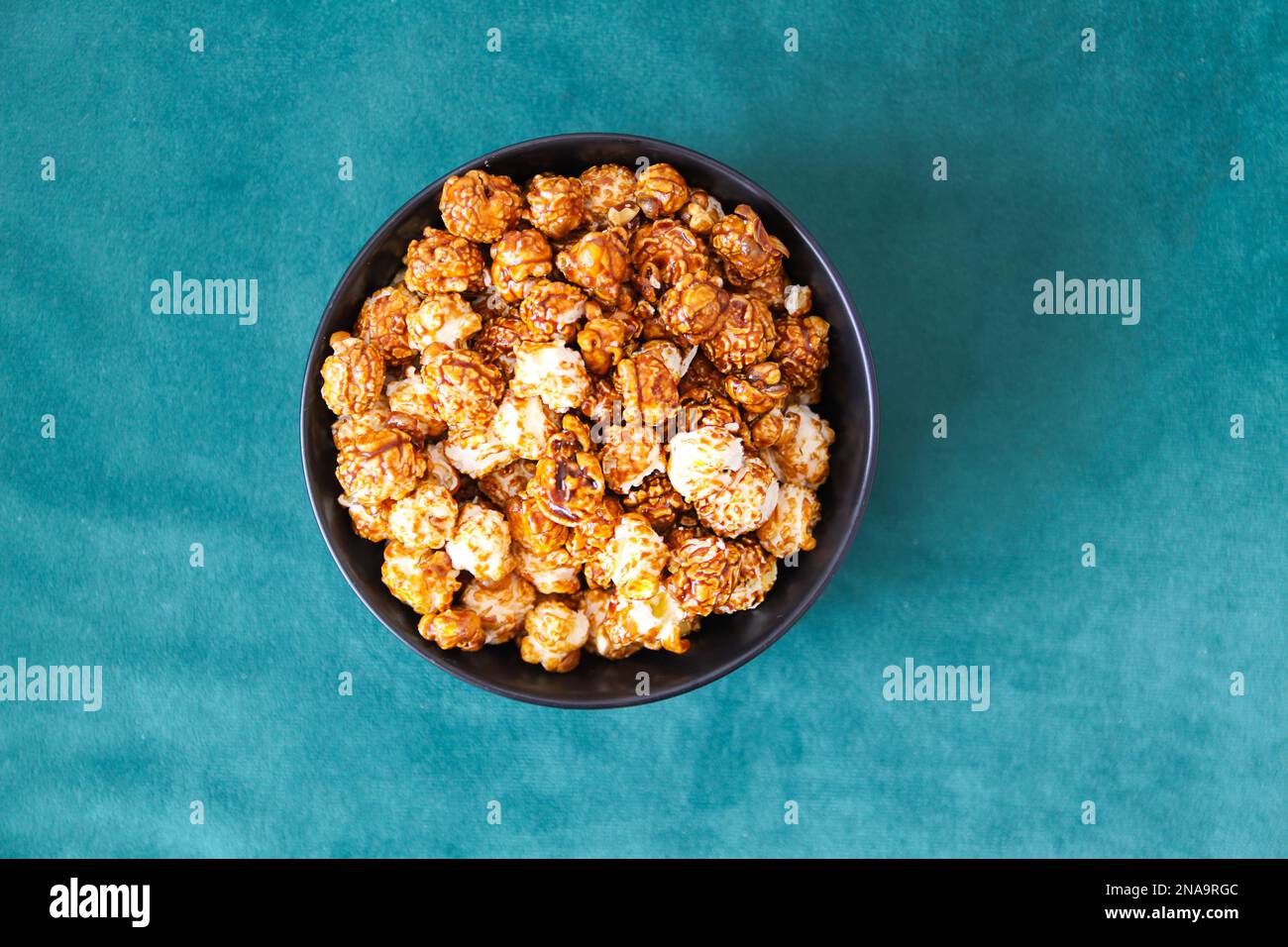Sweet ready-to-eat popcorn in a black ceramic plate close up Stock ...