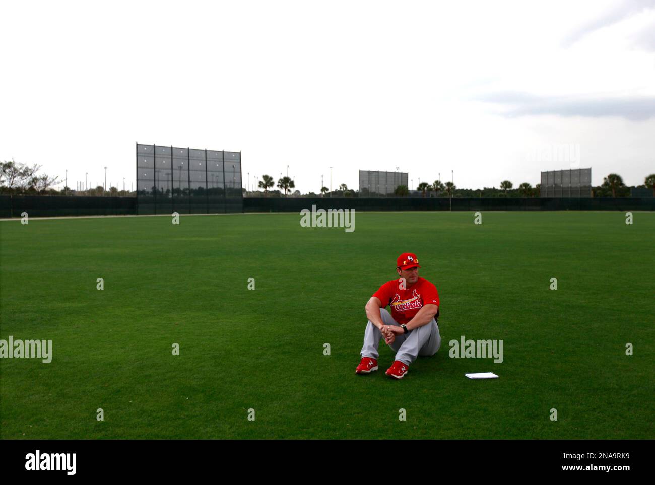 New St. Louis Cardinals manager Mike Matheny sits on the grass as he ...