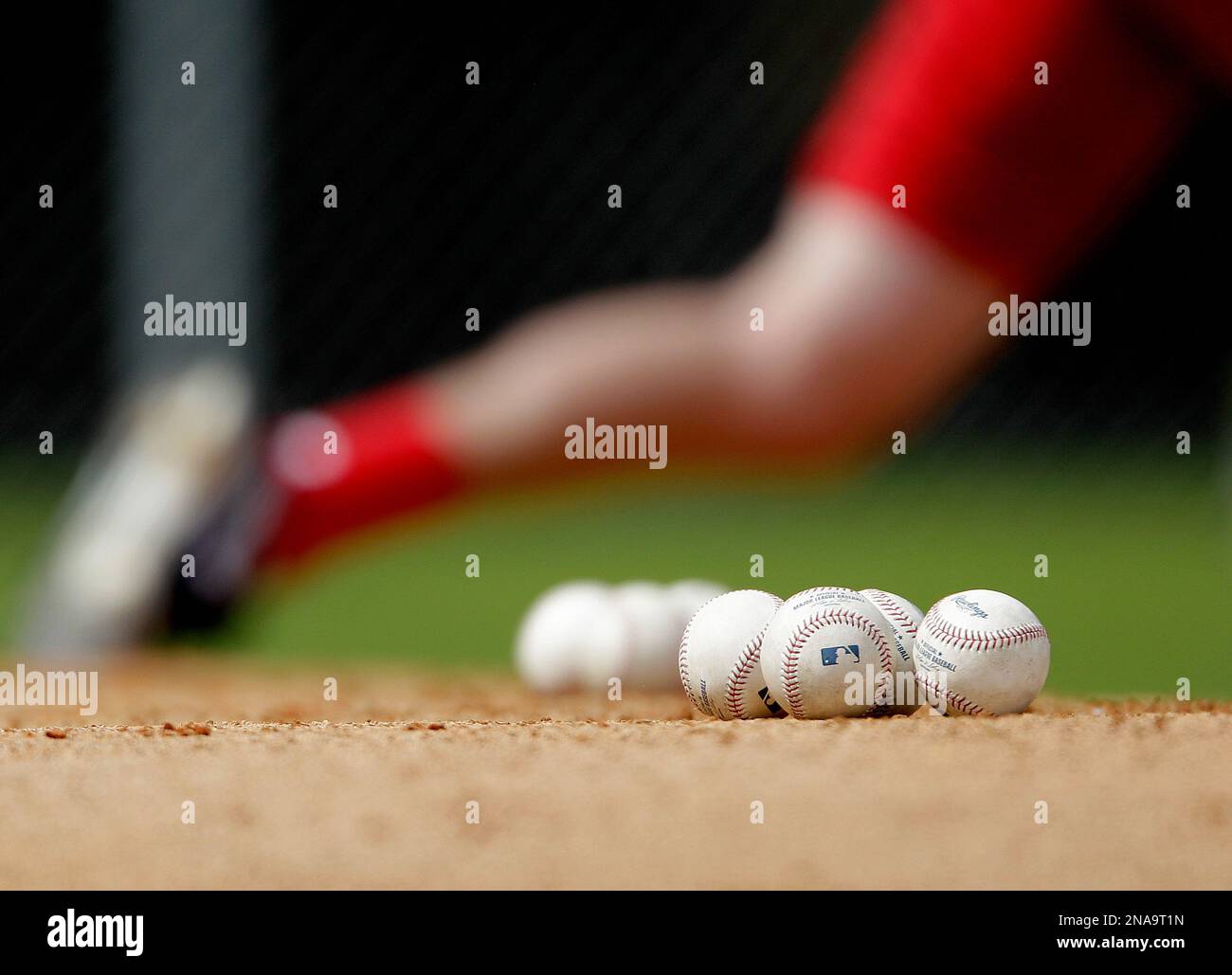 Baseballs sit in the dirt as Andrew Miller throws in the background as ...