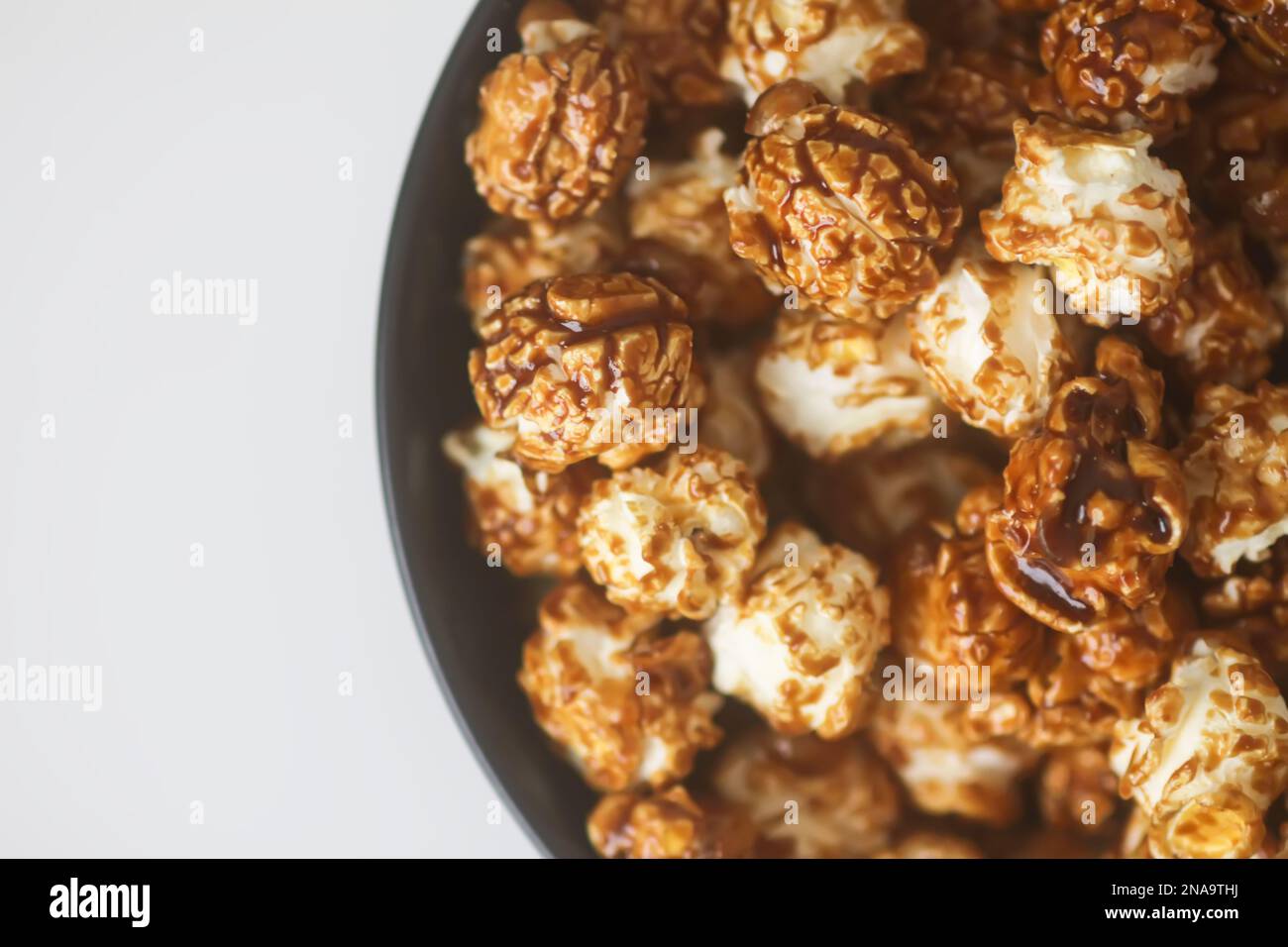 Sweet ready-to-eat popcorn in a black ceramic plate close up Stock ...