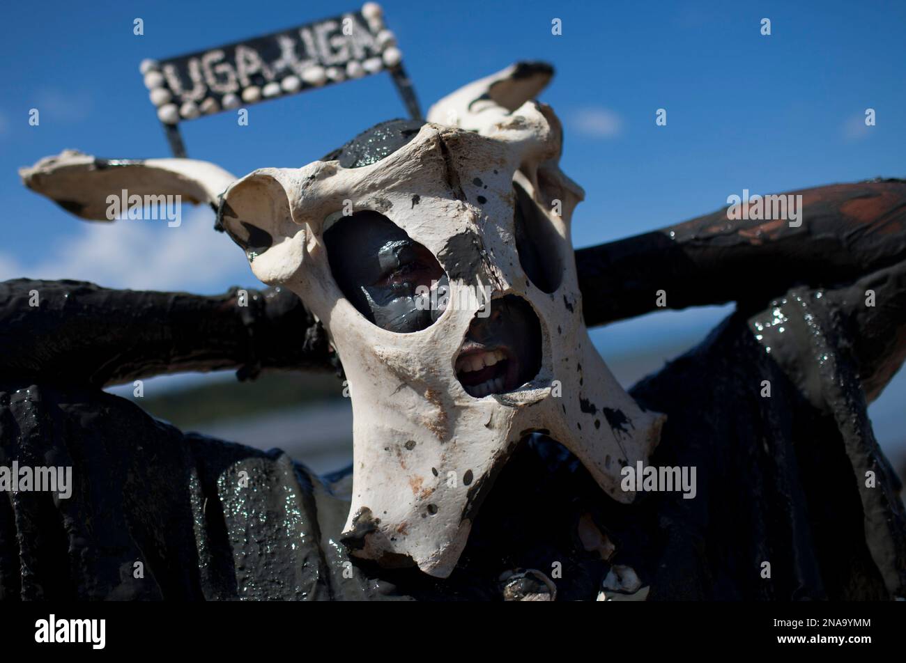 A mud covered reveler wears a costume during the "Bloco da Lama," or ...