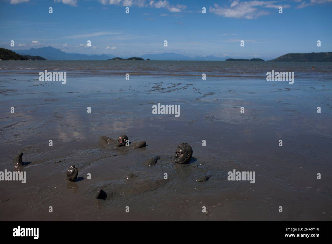 Revelers lie in the mud during the "Bloco da Lama," or "Mud Block ...